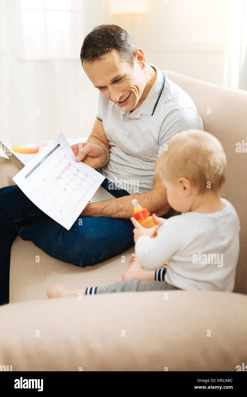 Smart emotional father showing his graphic to a busy little child Stock ...