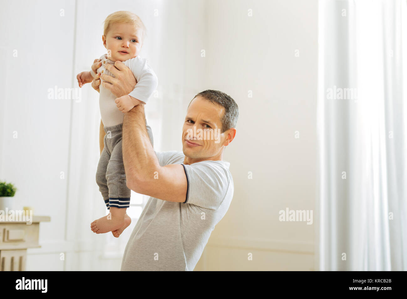 Upset young father carrying his baby and feeling unsatisfied Stock ...