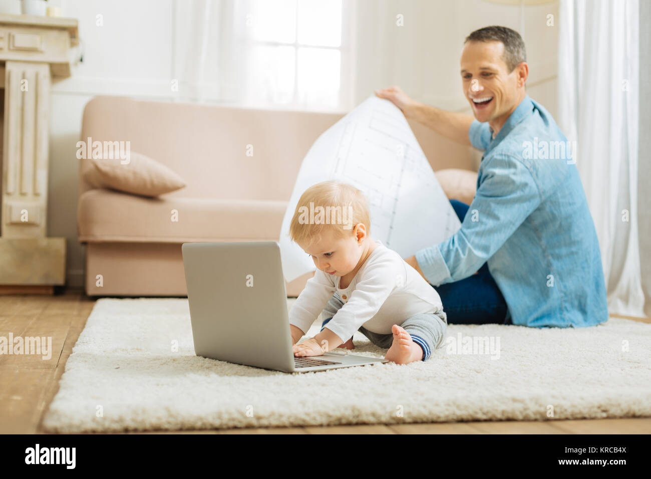 Modern baby typing on the laptop while the father looking at it Stock ...