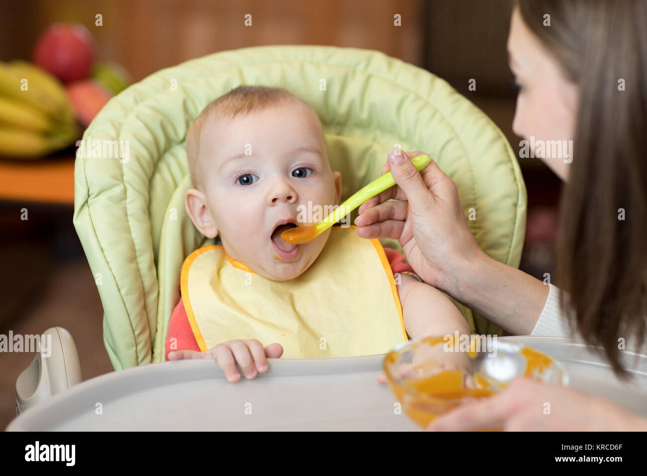 Baby eating healthy food with mother help at home Stock Photo - Alamy