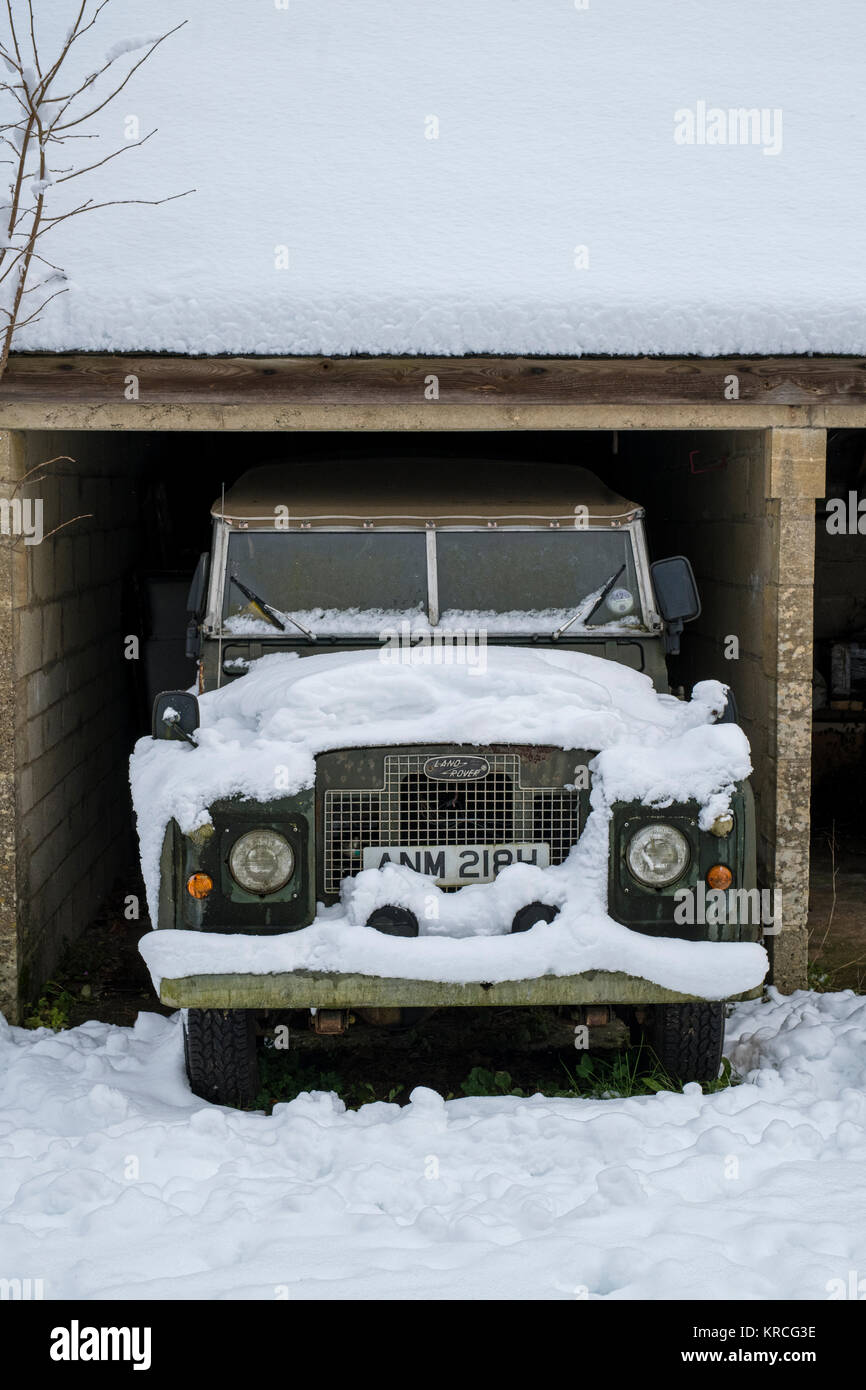 Vintage 1969 Land Rover covered in snow parked in an open garage ...