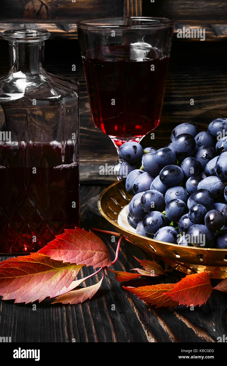 Young red wine in the glass from the autumn harvest of grapes.Dark key ...