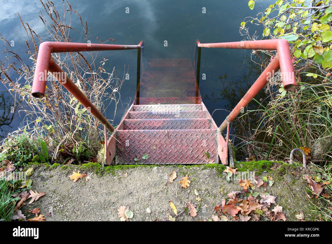 Strong metal steps with metal pipe handrail connected to concrete pier ...