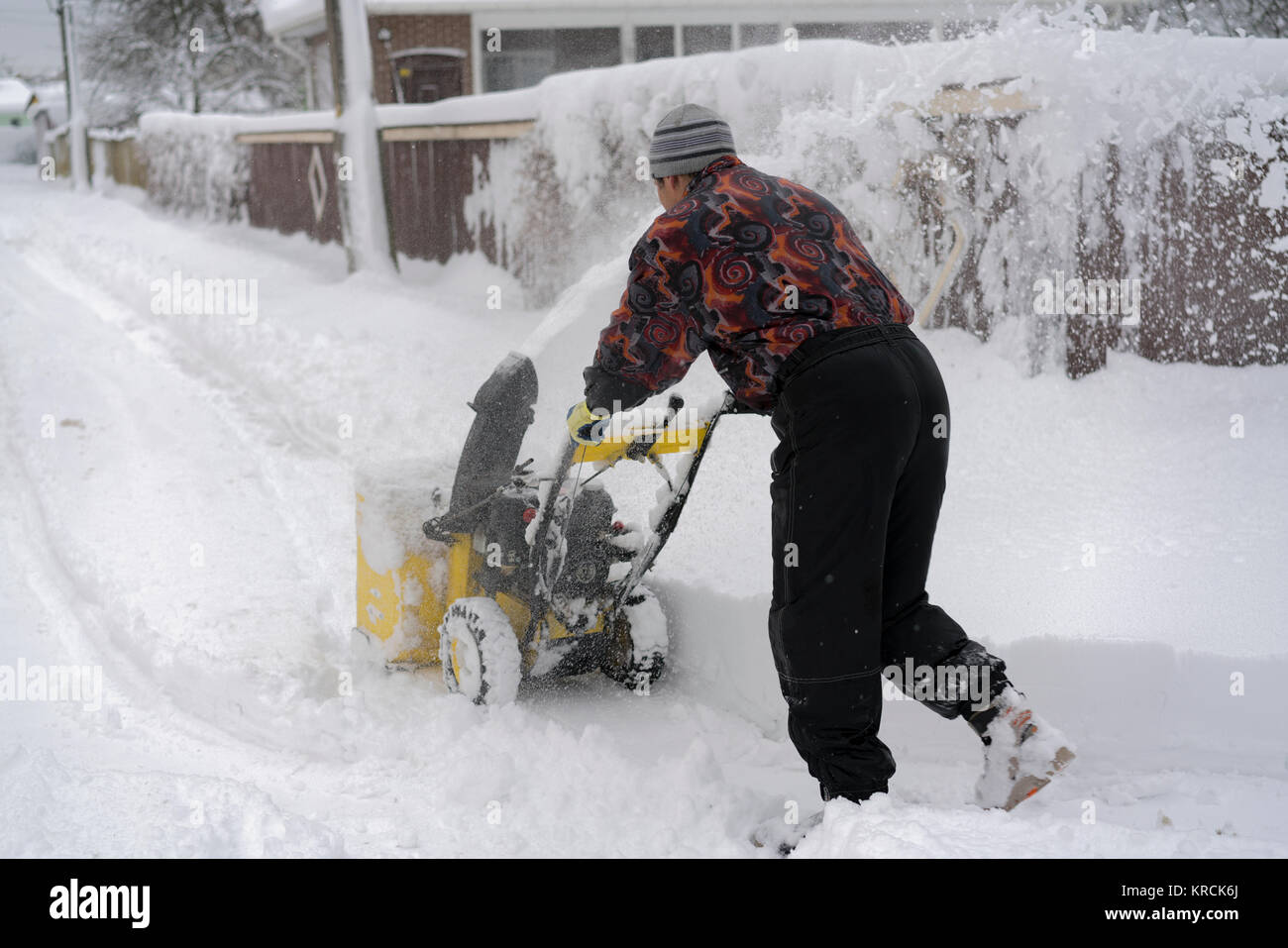 A man cleans snow from sidewalks with snowblower Stock Photo - Alamy