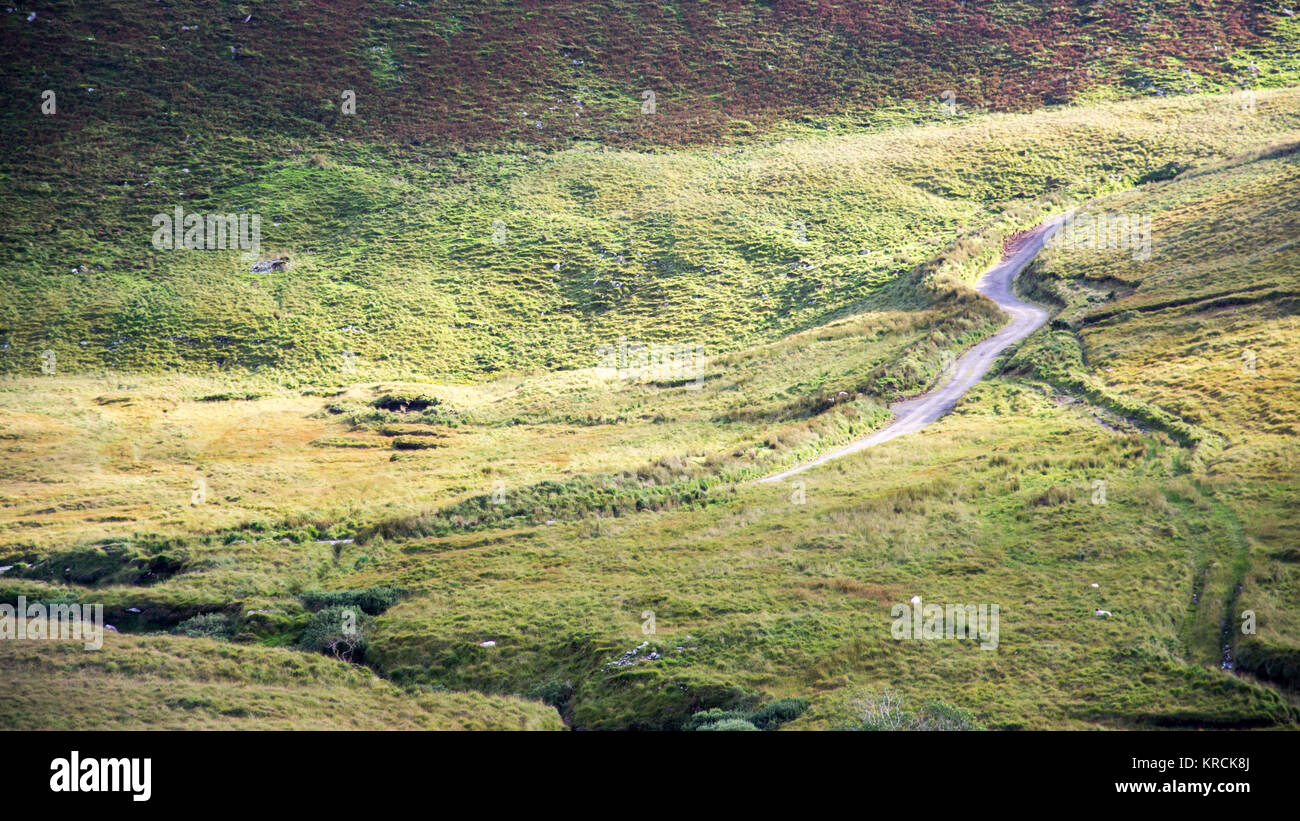 A narrow mountain pass road crosses moorland on Caherconree in the ...