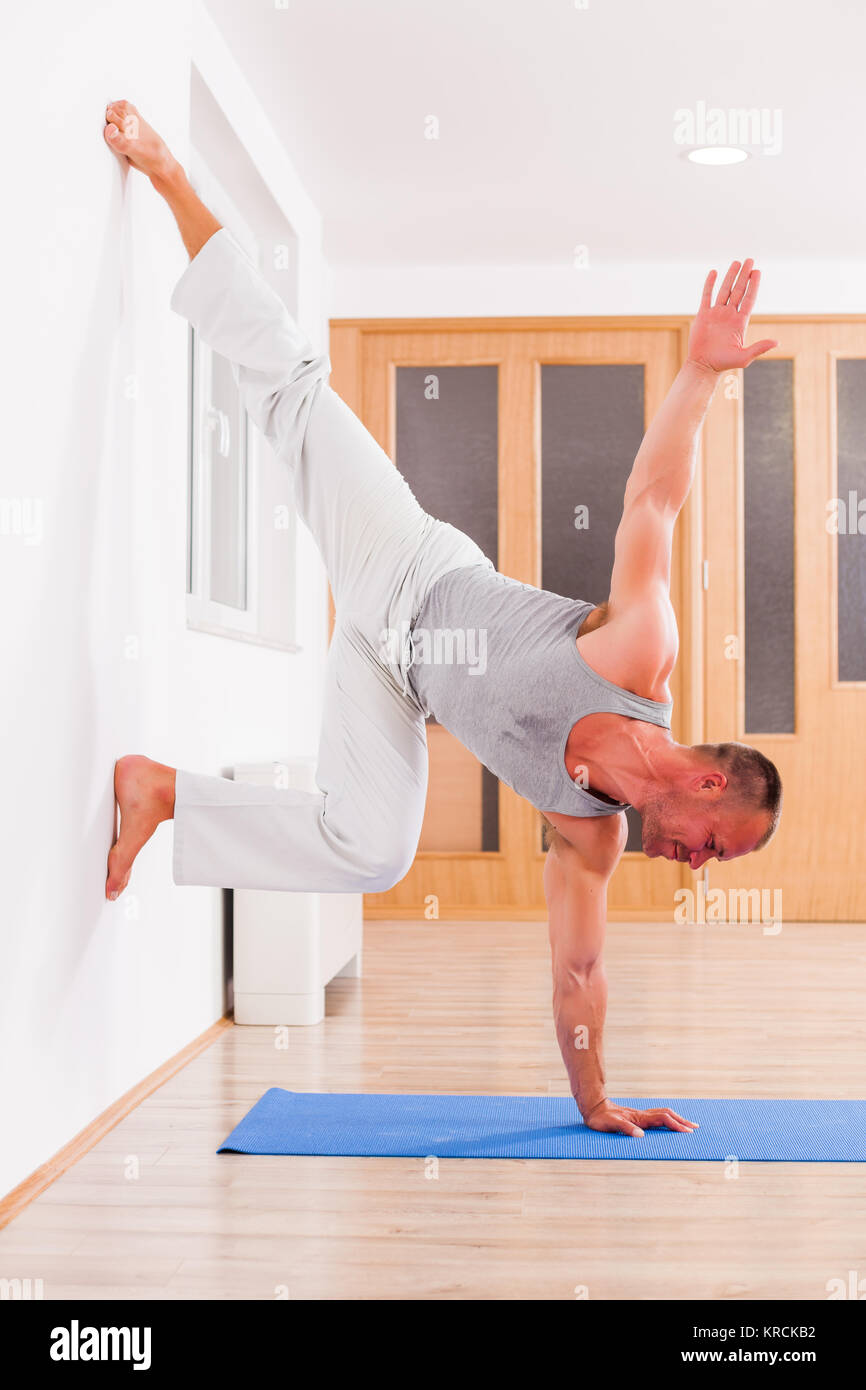 Adult man practicing yoga, Vrksasana / Handstand pose Stock Photo - Alamy