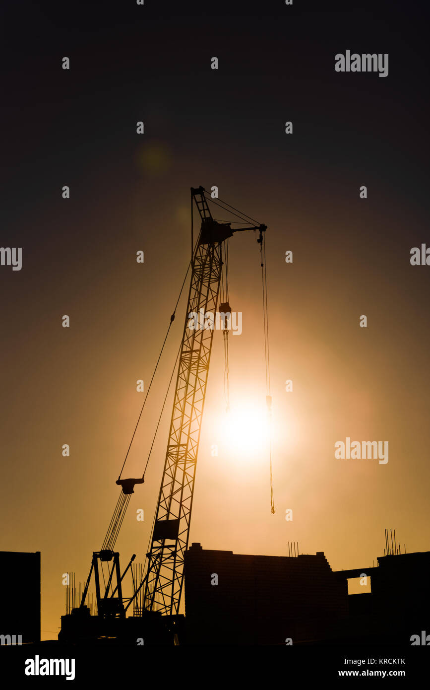 Tower crane on a construction site at sunset Stock Photo - Alamy