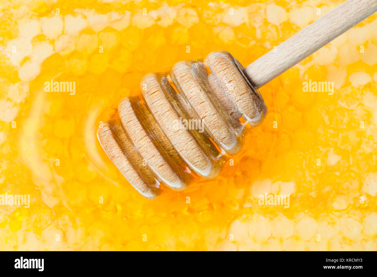 wooden honey dipper on surface of honeycomb Stock Photo - Alamy
