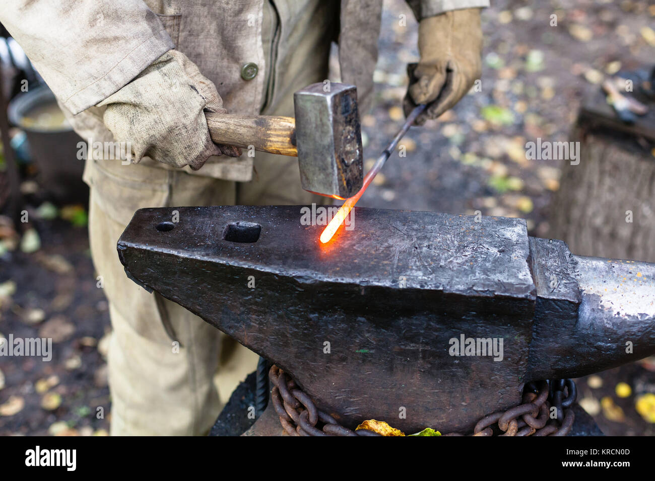 Blacksmith hammering hot steel rod on anvil Stock Photo - Alamy