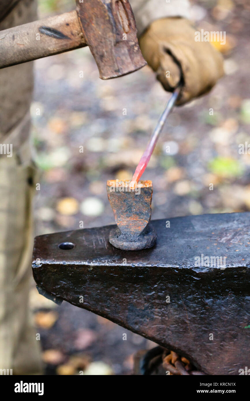 Blacksmith cut out rod with hammer and chisel Stock Photo - Alamy