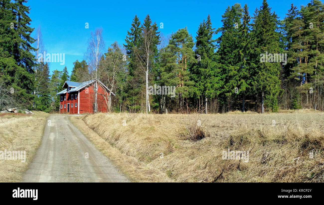 A Scandinavian barn in classic red and white paint at the end of a road ...