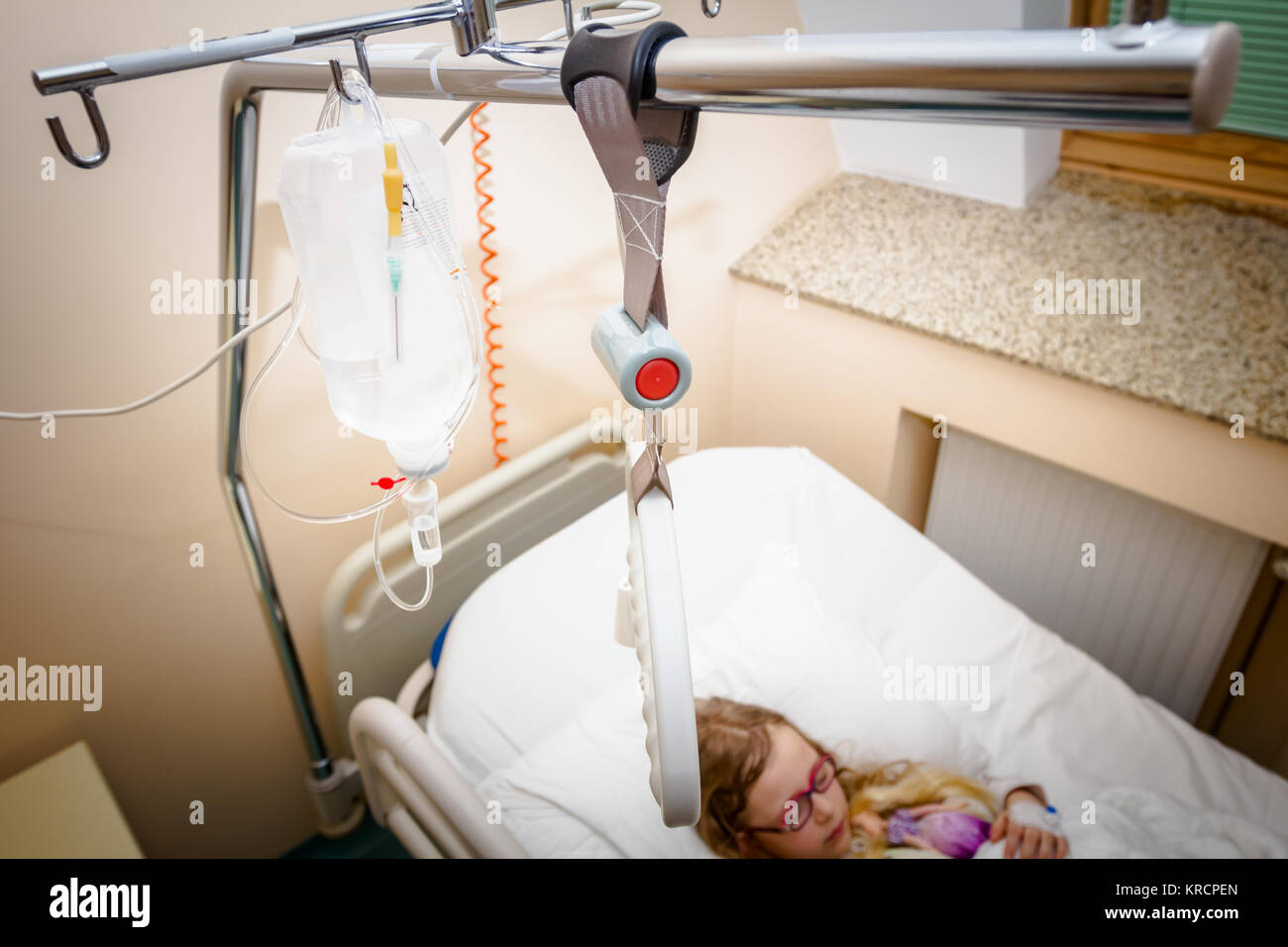 Above hospital bed is hanging adaptive triangular metal frame and bag ...