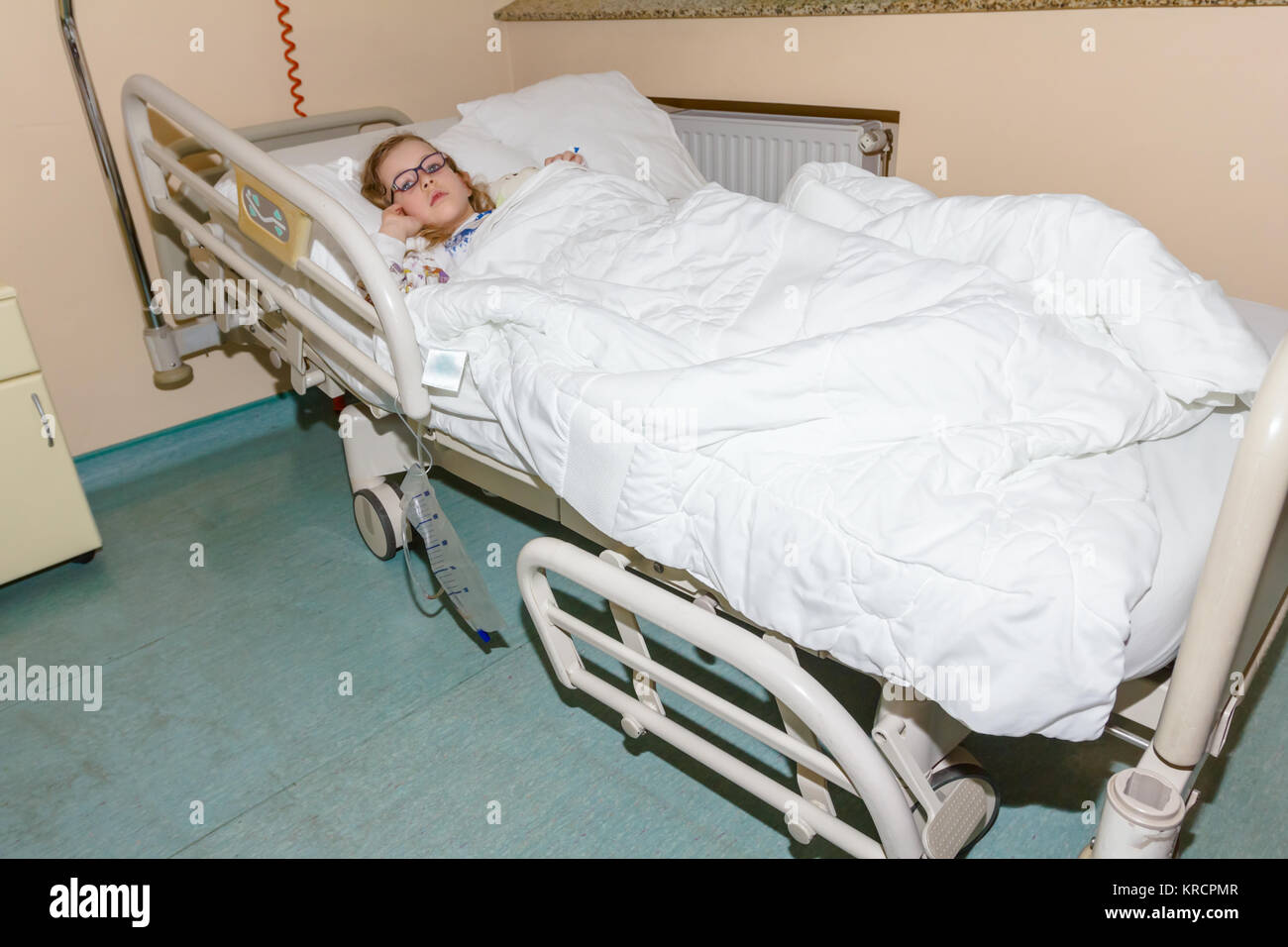 Little girl is resting in a hospital bed with her teddy bear, clinic ...