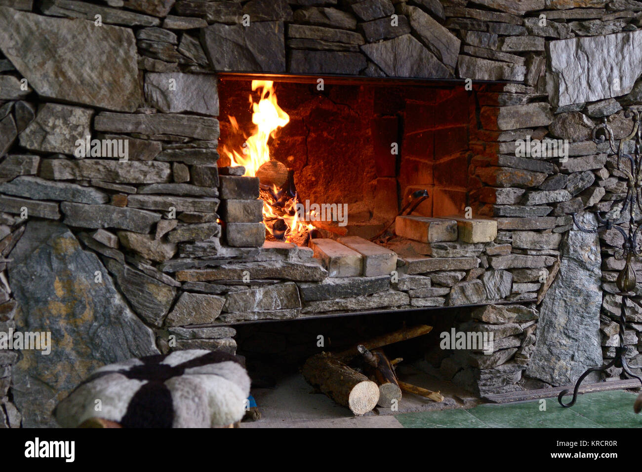 Close up of stone fireplace with burning logs Stock Photo - Alamy