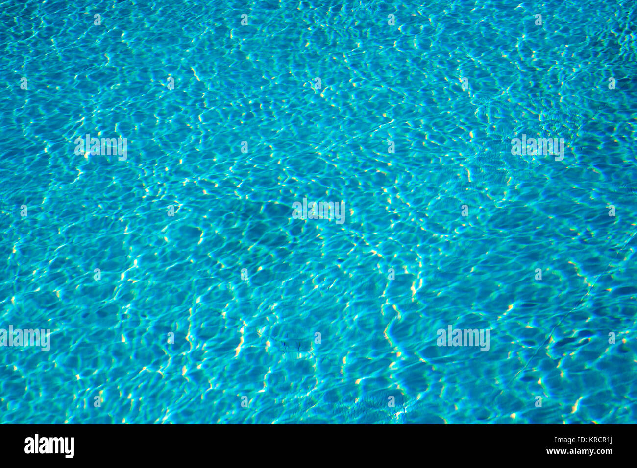 Textured light effect on the surface ripples of a blue outdoor swimming ...