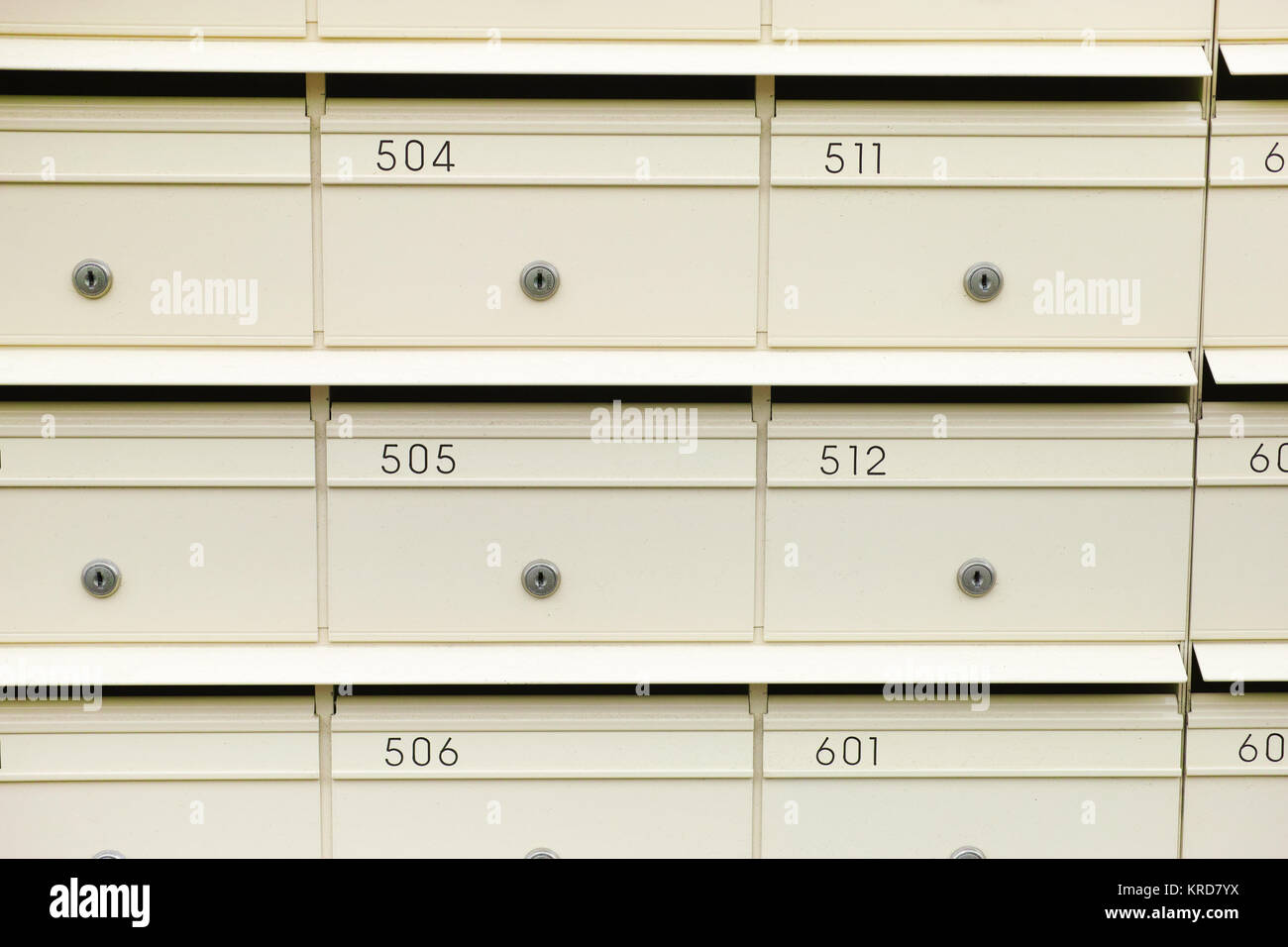 Close-up of a row of cream colored urban mailboxes with numbers, letter ...