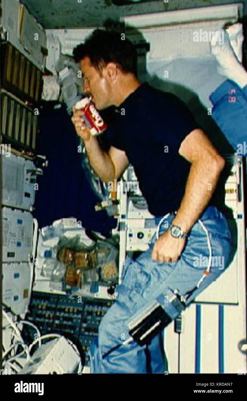NASA shuttle astronaut drinks from a specially designed Coke beverage ...