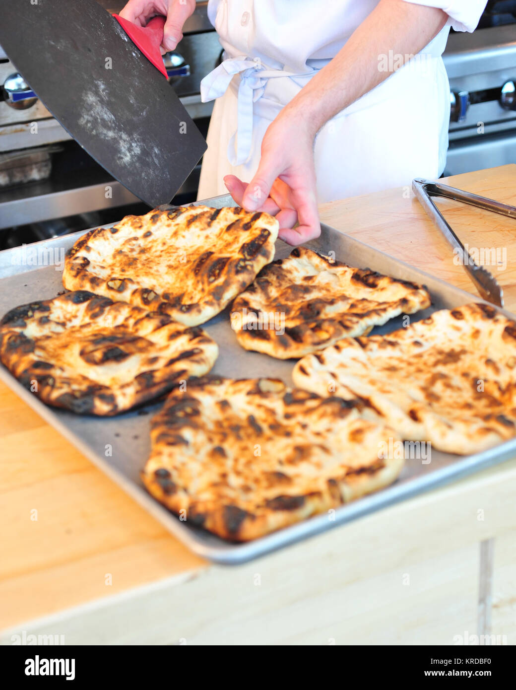 Naan bread on a baking tray Stock Photo - Alamy