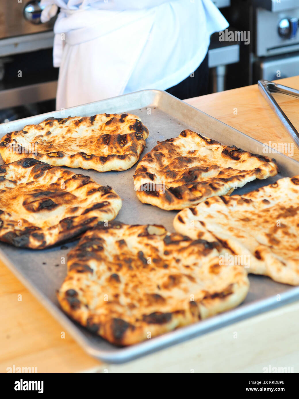 Naan bread on a baking tray Stock Photo - Alamy