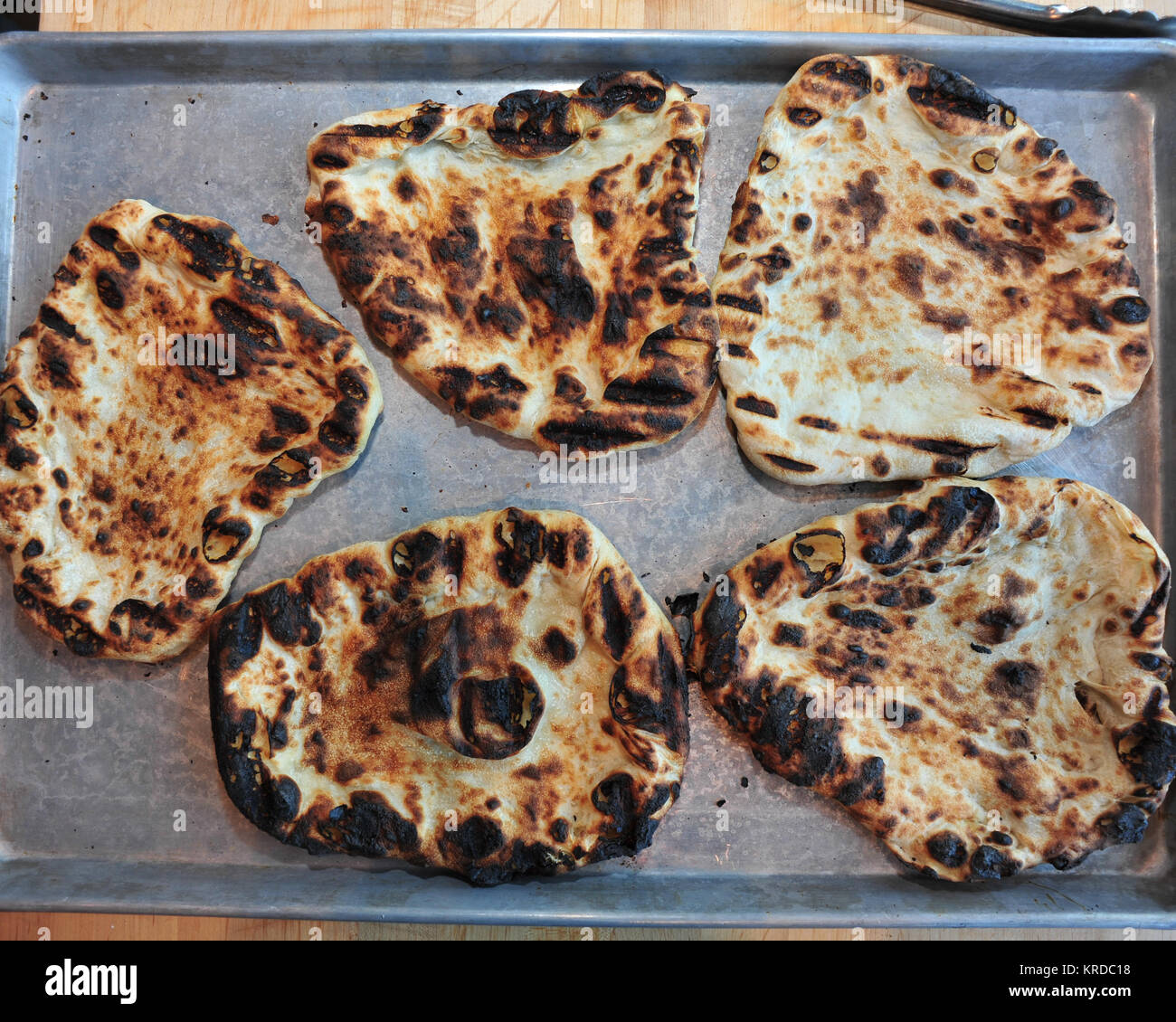 Naan bread on a baking tray Stock Photo - Alamy