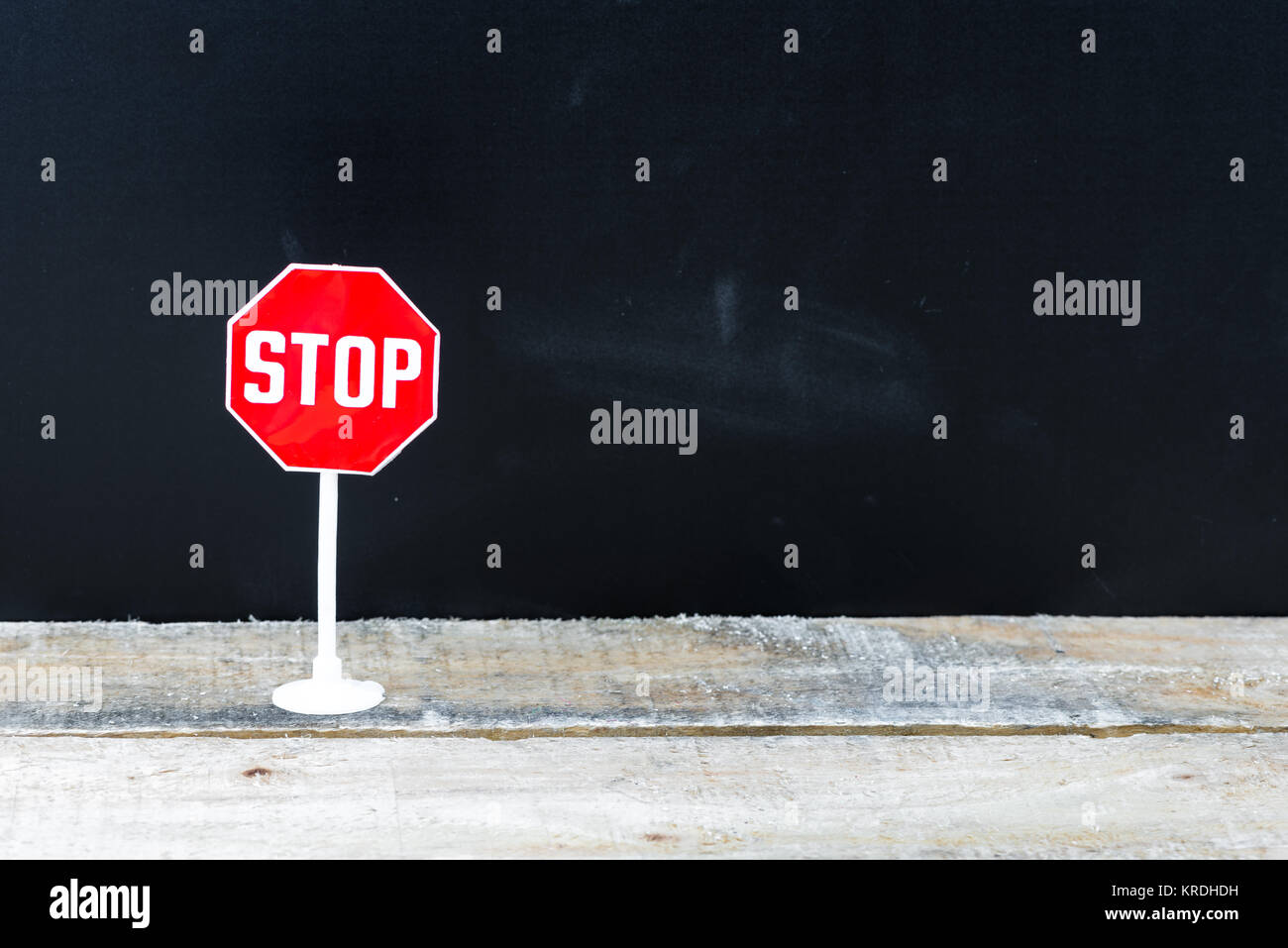 Mini STOP sign over chalkboard background and table Stock Photo - Alamy