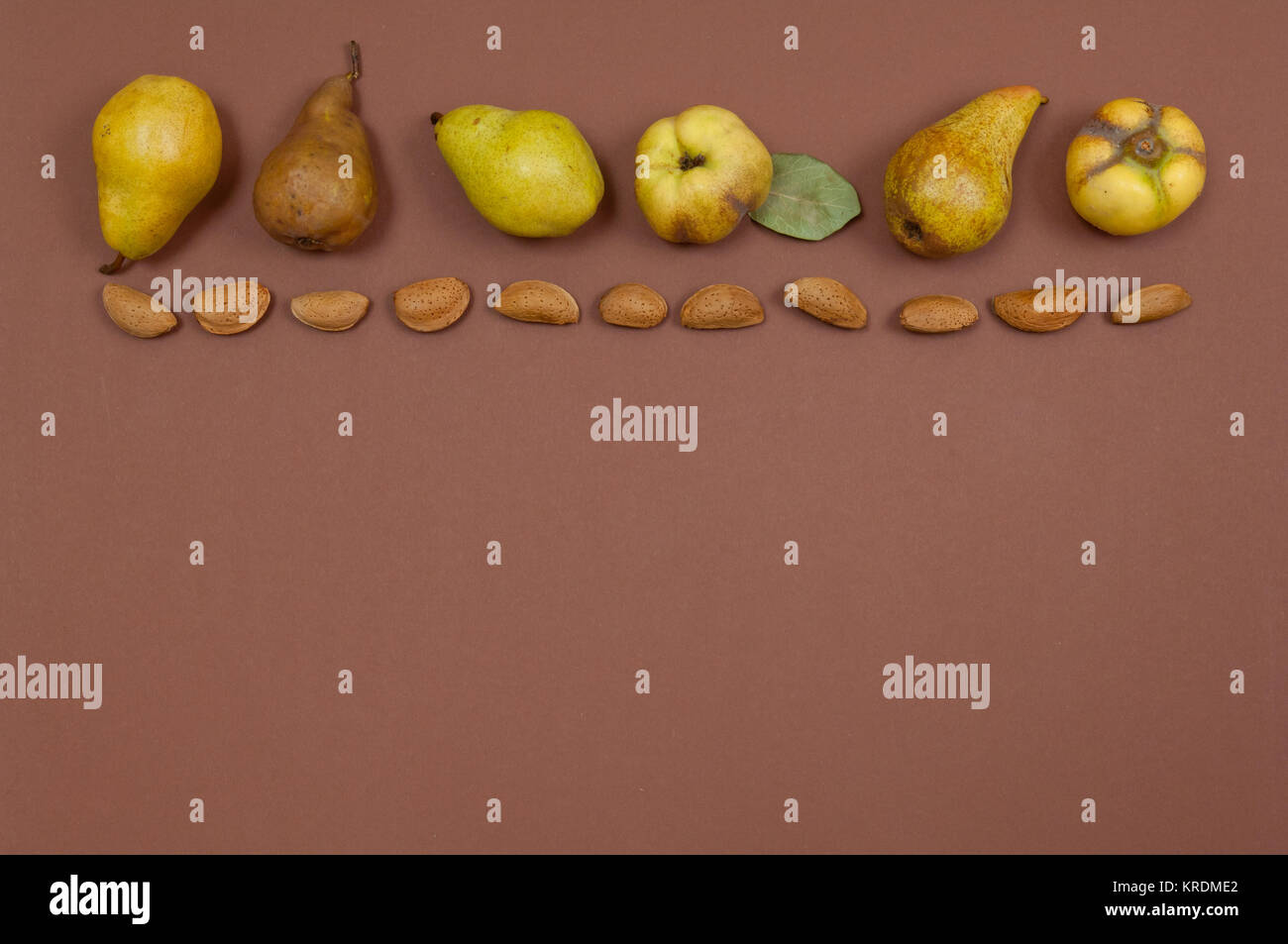 Pears and almonds row on yellow background with copy space Stock Photo ...