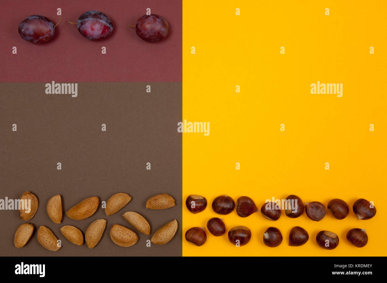 Hard shell nuts and plums on split background Stock Photo - Alamy