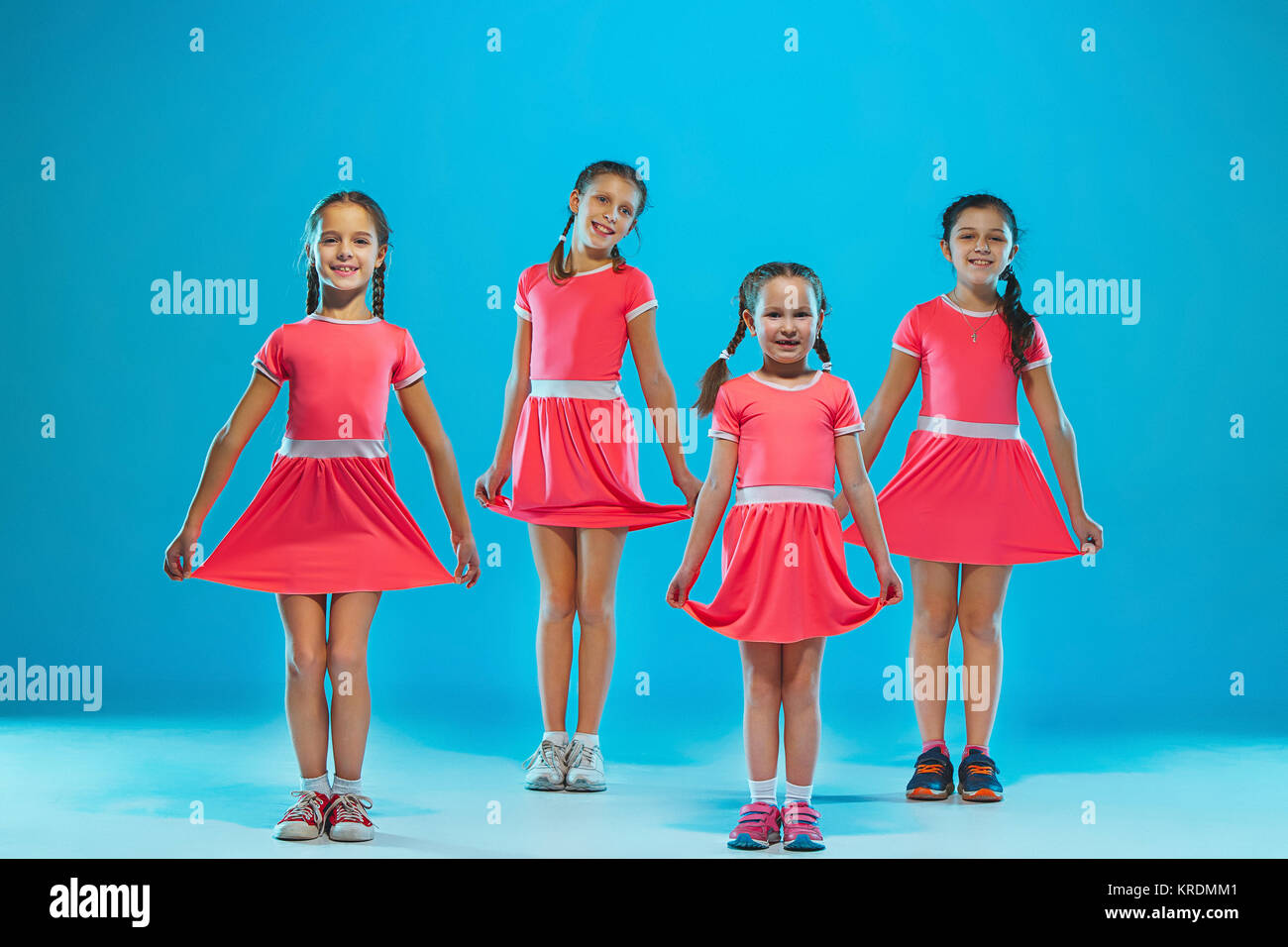 Cute funny girls dancing on blue background Stock Photo - Alamy