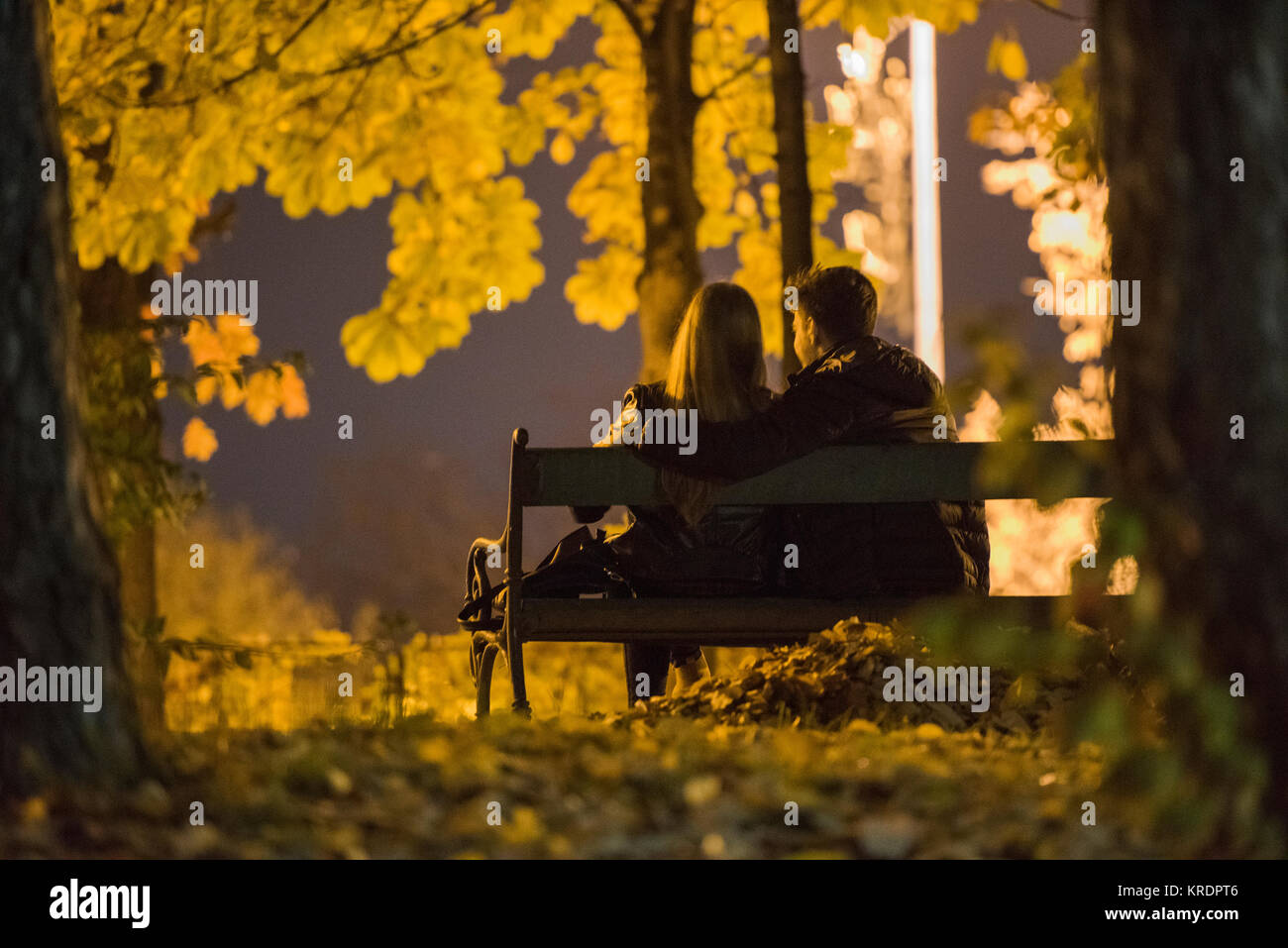 Couple on a bench in an autumn evening Stock Photo - Alamy