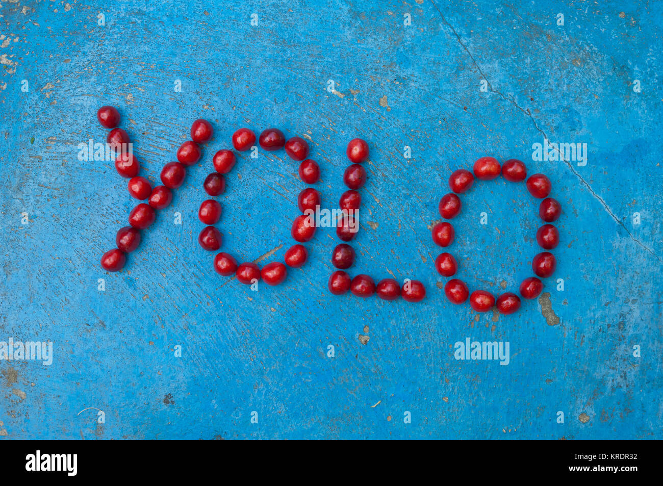 Cherries arranged to form the word YOLO on blue background Stock Photo ...