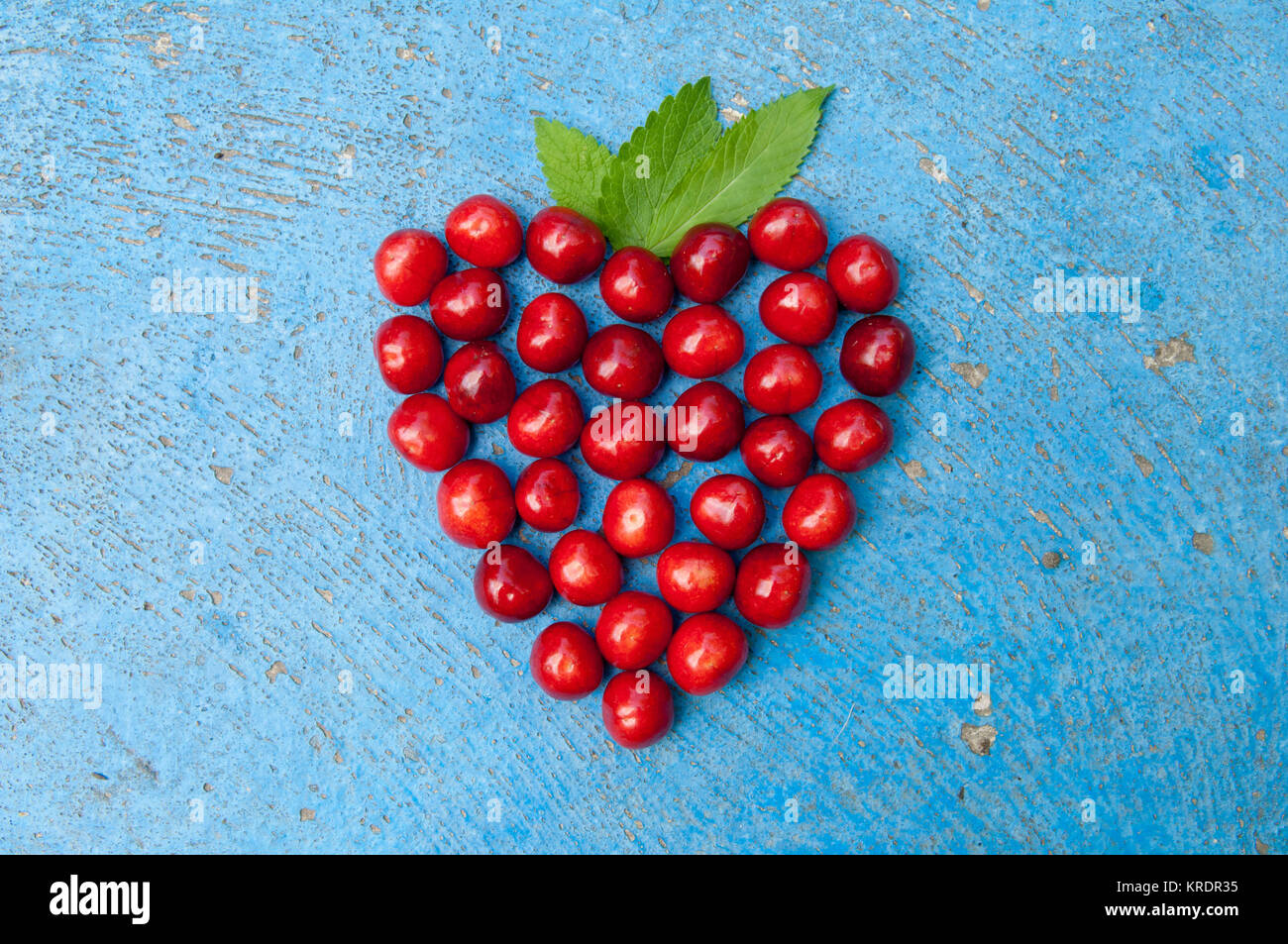 Heart shaped cherries on blue background cherry heart Stock Photo - Alamy
