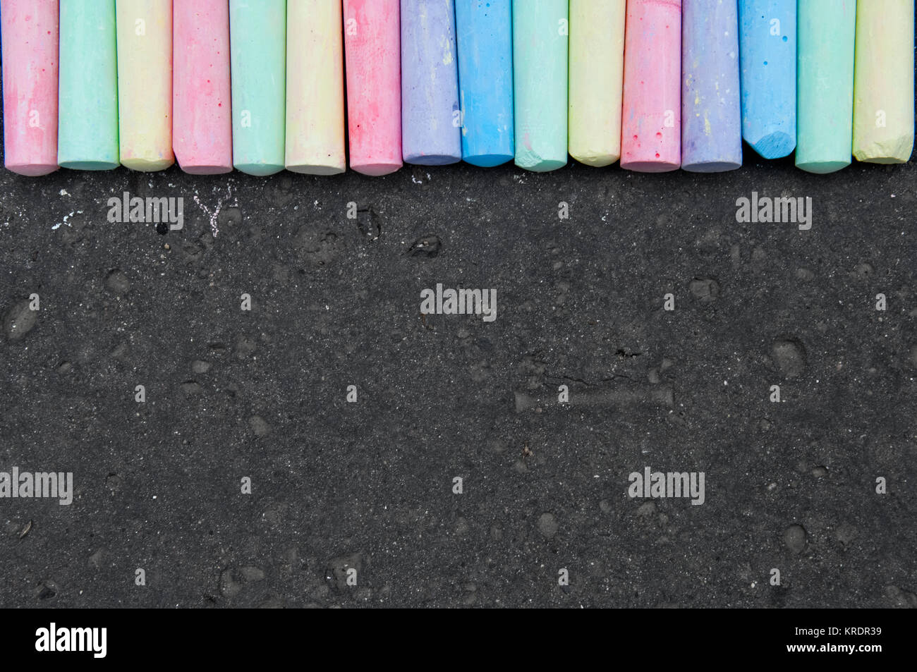 Colorful pastel sidewalk chalk on dark asphalt background Stock Photo ...