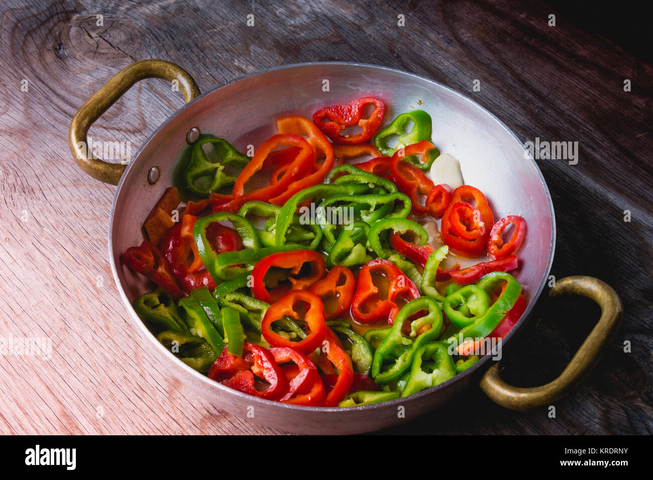 Green and red peppers frying in a pan Stock Photo - Alamy