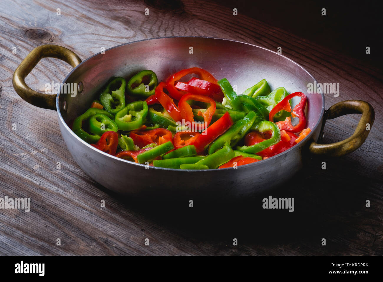 Green and red peppers frying in a pan Stock Photo - Alamy