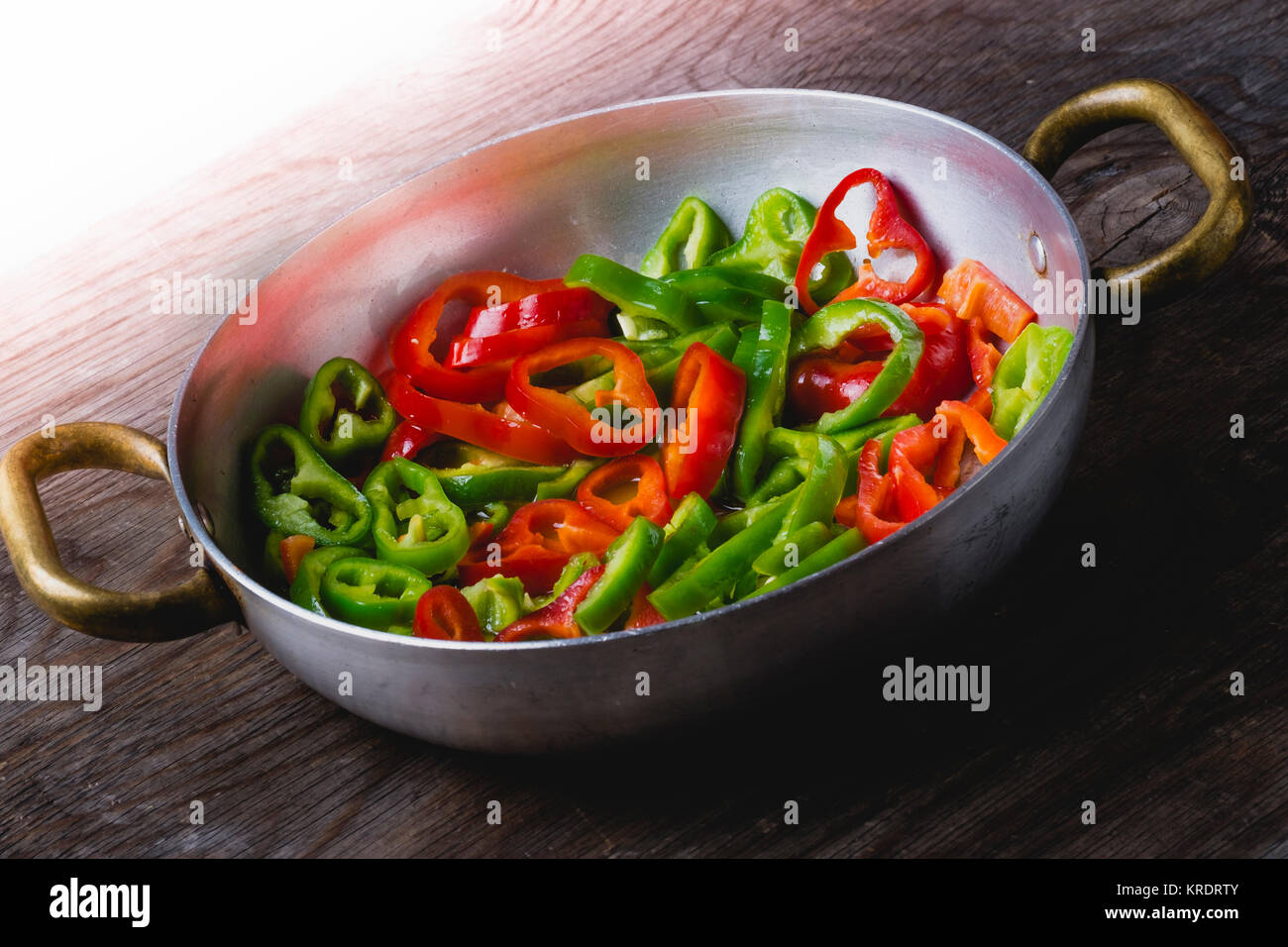 Green and red peppers frying in a pan Stock Photo - Alamy