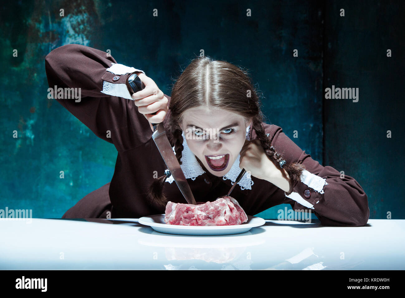 Bloody Halloween theme: crazy girl with a knife, fork and meat Stock ...
