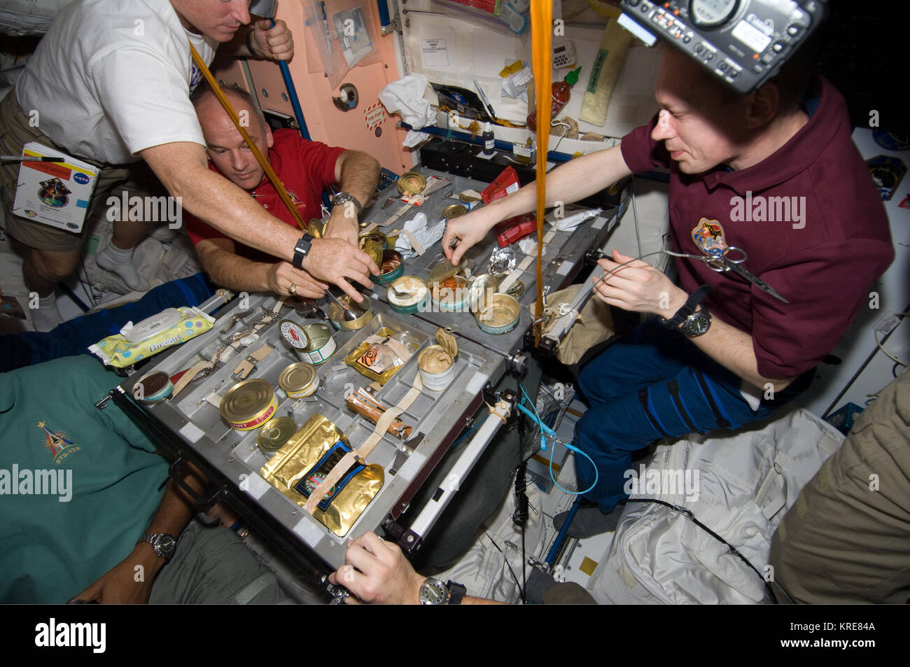 STS-129 crew members gather for a meal at the galley in the Unity node ...