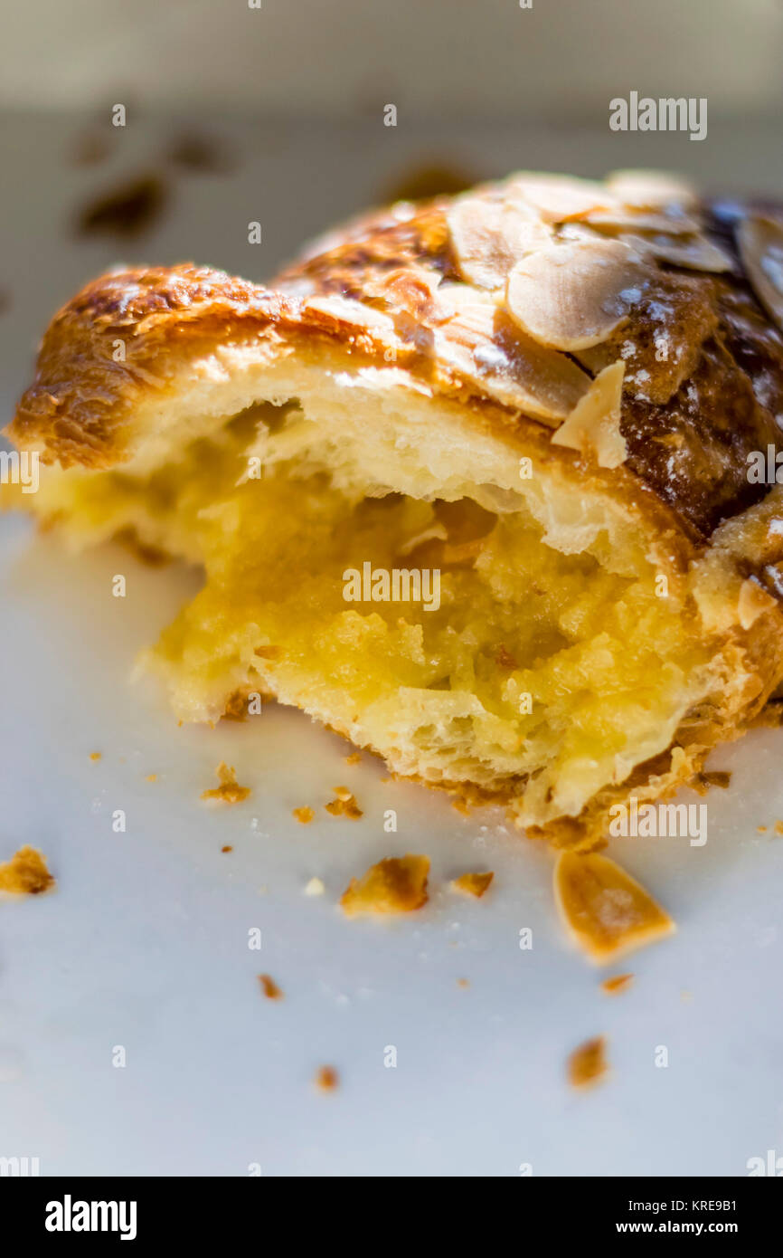 Almond croissant half in white paper box, macro Pastry half, almond ...