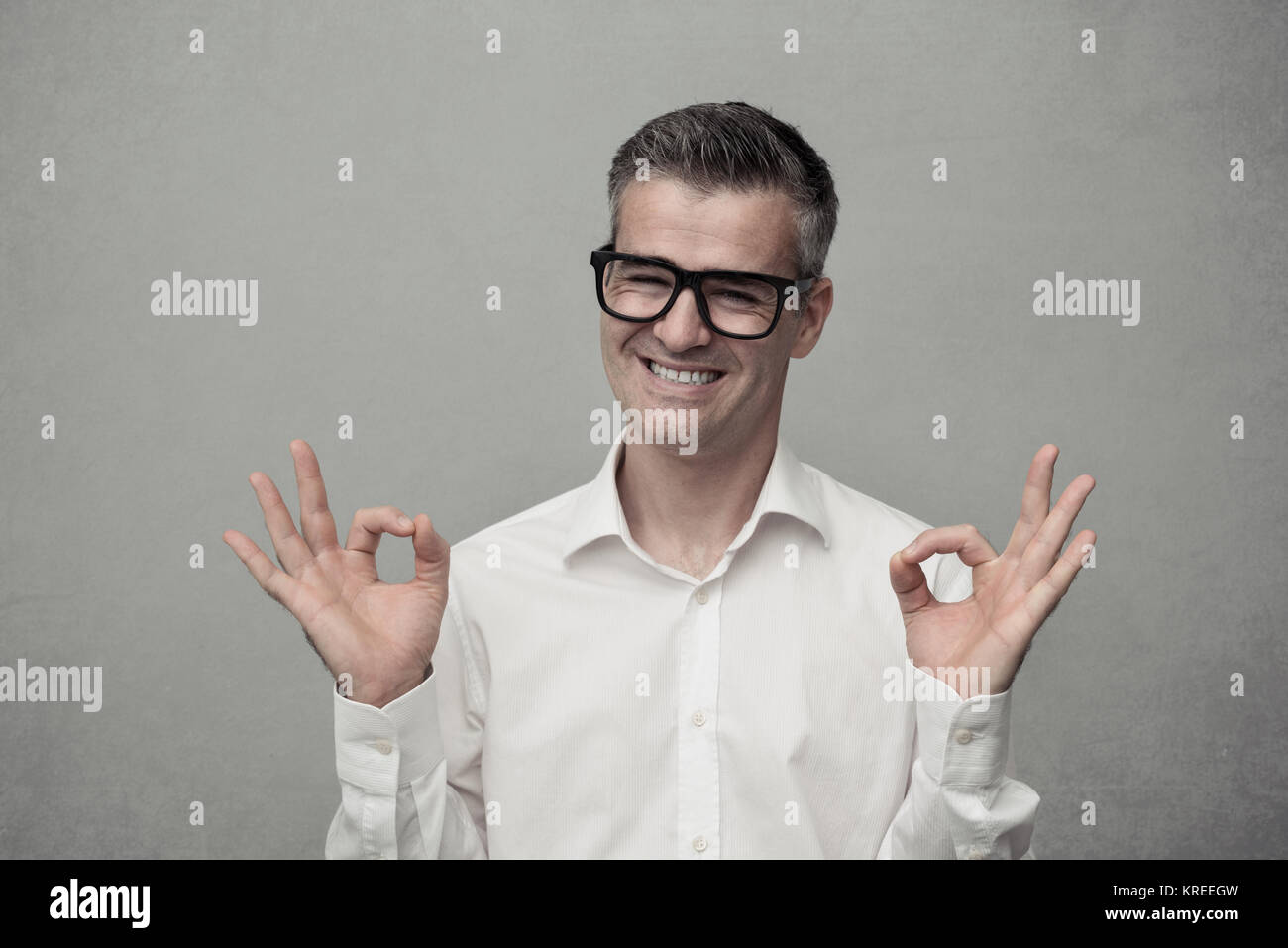 Satisfied happy man showing an OK sign and smiling at camera Stock ...