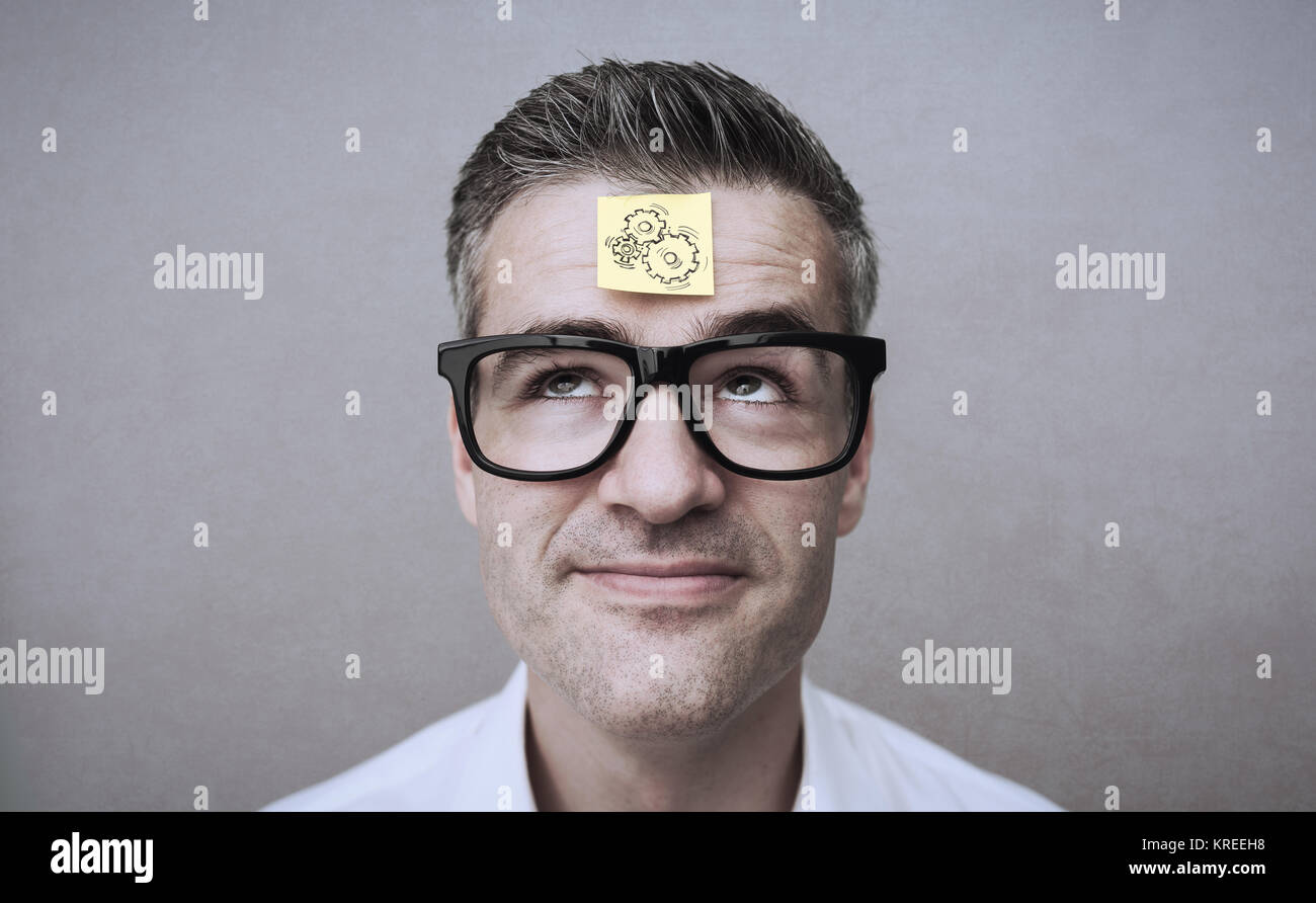 Forgetful careless smiling man with a blank sticky note on his forehead ...
