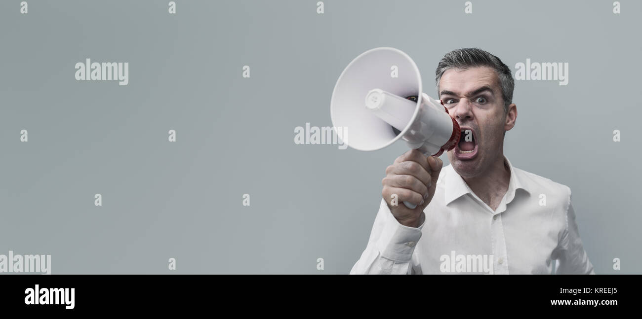 Aggressive man shouting with a megaphone and spreading his message ...