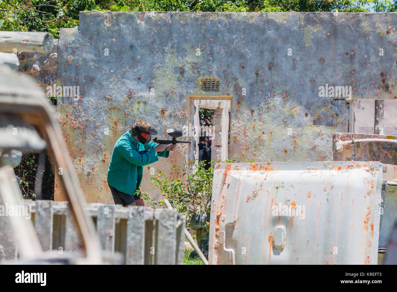 Paintball game action arena player gun in old broken house outdoors ...
