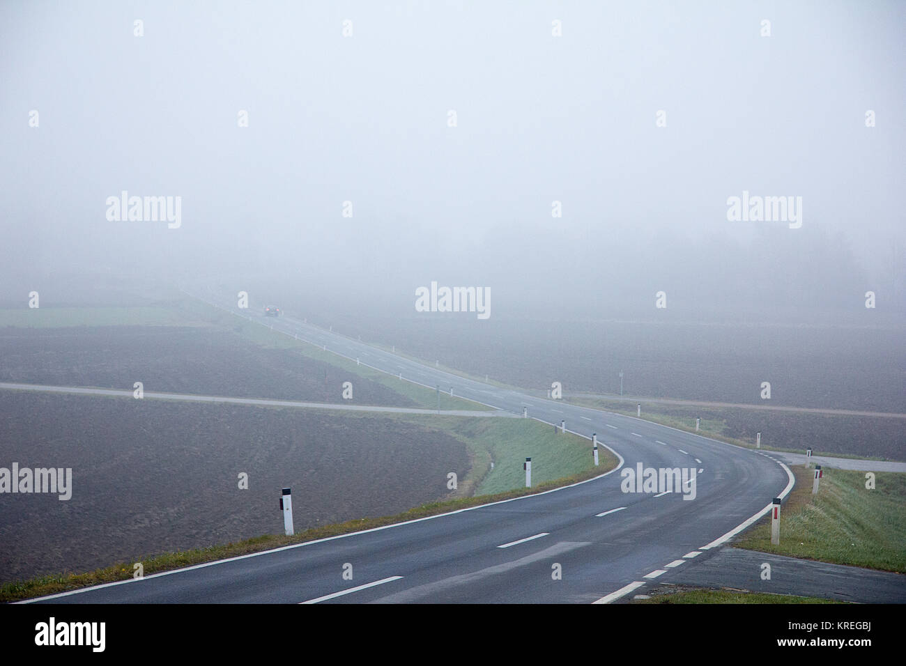 road without vehicles through rural area in fog Stock Photo - Alamy