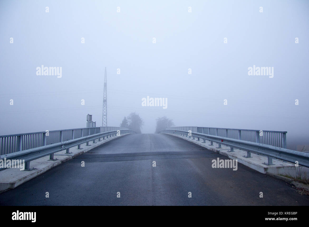 road without vehicles over bridge in fog Stock Photo - Alamy