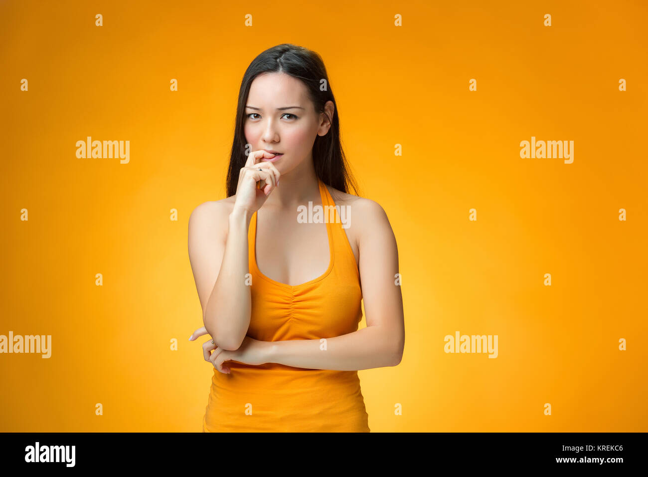 The thinking Chinese girl on yellow background Stock Photo - Alamy
