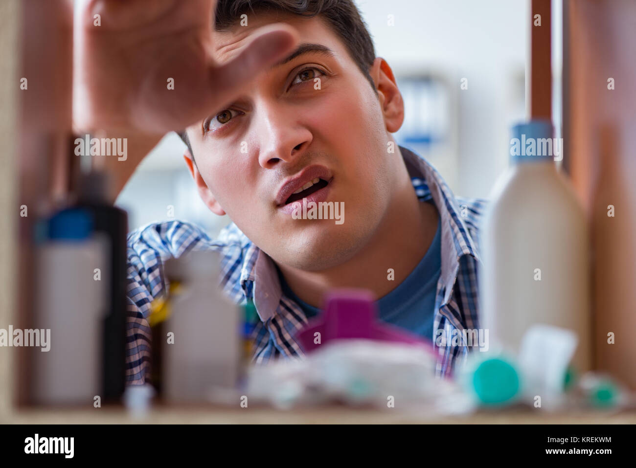 Sick ill man looking for medicines at farmacy shelf Stock Photo - Alamy