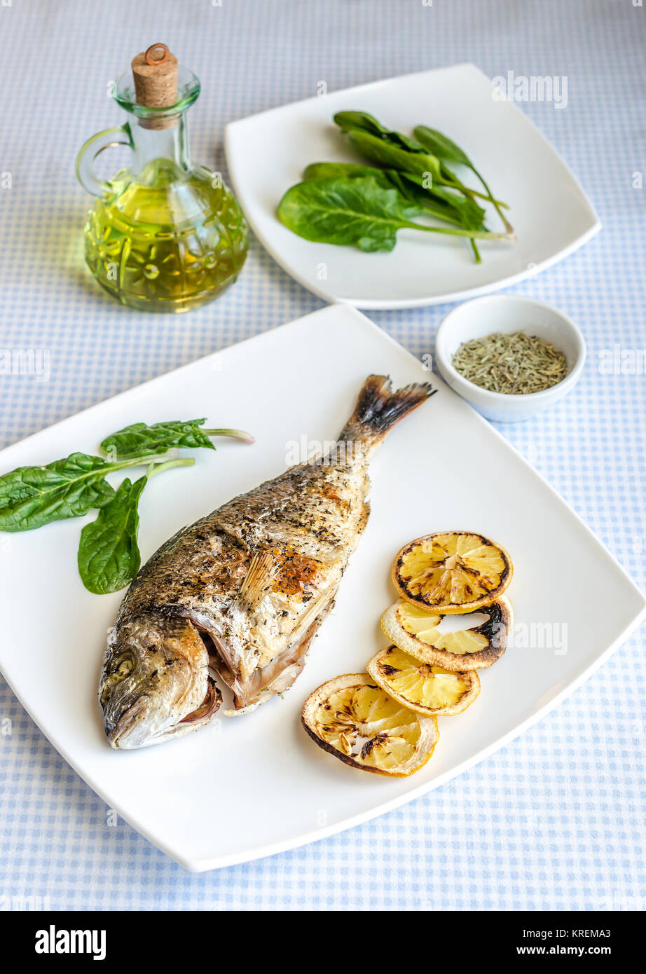 Grilled dorada fish with lemon and spinach Stock Photo - Alamy