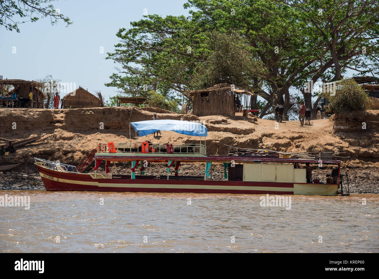 Boat carries tourists for river cruise along Mania River. Madagascar ...