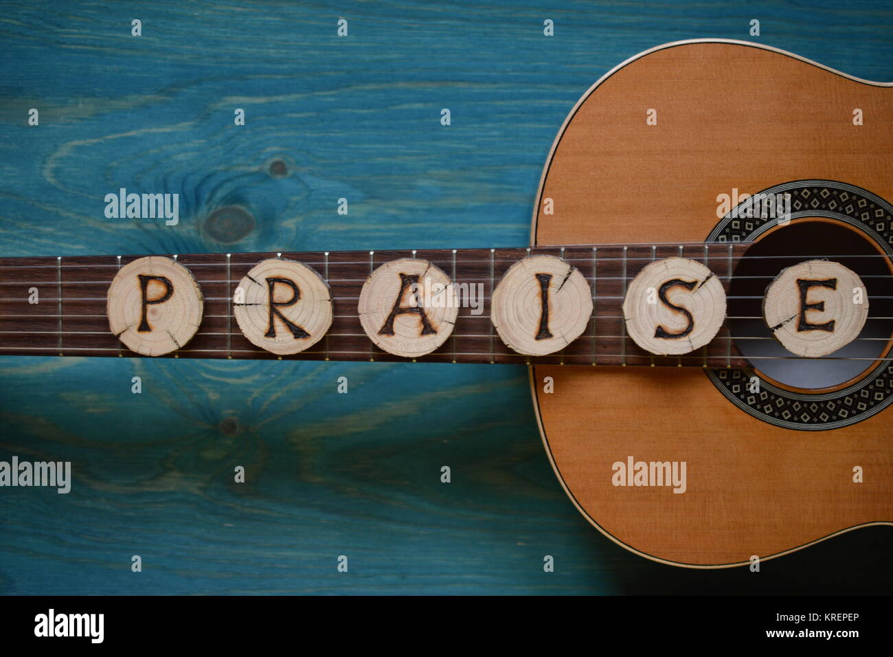 guitar on blue green wood with word: praise Stock Photo - Alamy