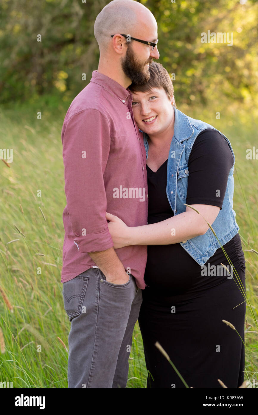 Man and a pregnant woman in a field in Oregon while the girl is in her ...